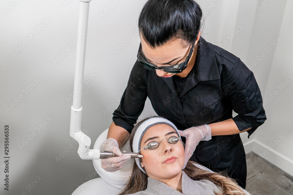 Beauty laser technician performing a cosmetic skin resurfacing session ...