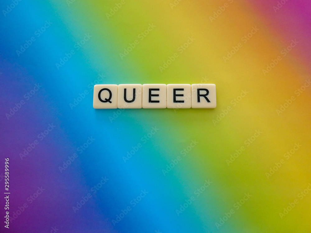 Bright rainbow colored background sign with the word "QUEER" in text ...