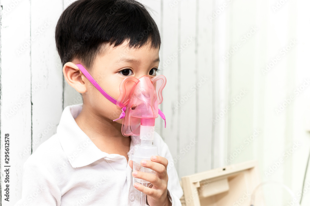 Asia boy using nebulizer and inhaler for the treatment. Little child ...