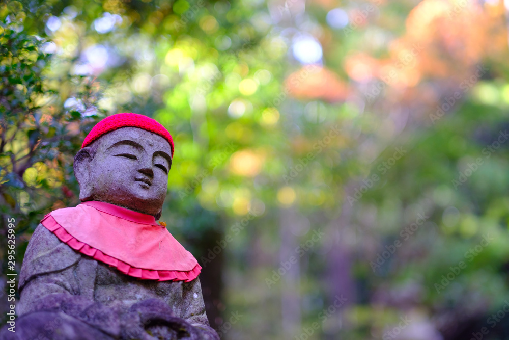Japanese god statue with red apron in mitakidera temple garden ...