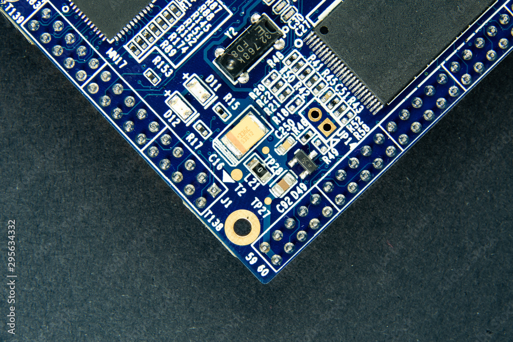 Corner of a computer module with chips, resistors and pins visible on a ...