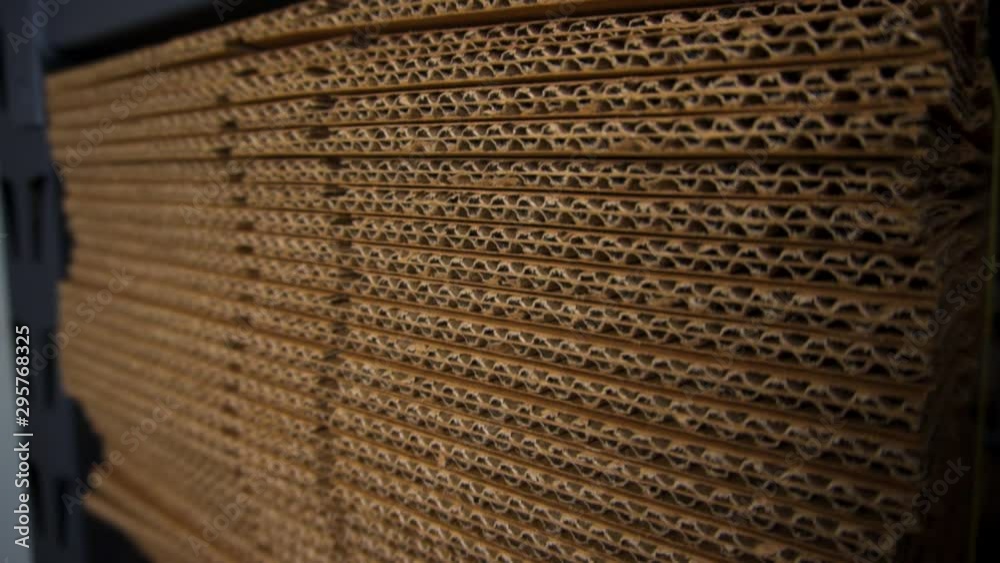 Tilt from top to bottom of big stack of flat cardboard boxes in slow ...