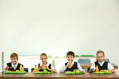 Happy children eating healthy food for lunch in school canteen Stock ...