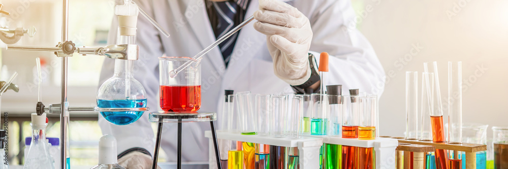 Scientist testing some chemical sample at laboratory with lab glassware ...