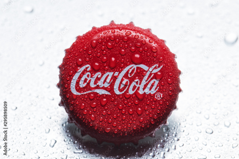 classic cap close-up of Coca-Cola on a gray background with drops of ...