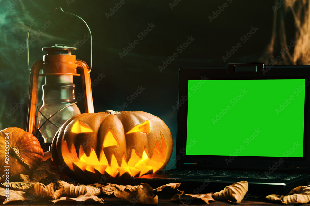 Halloween pumpkins and laptop with green screen in scary deep night ...