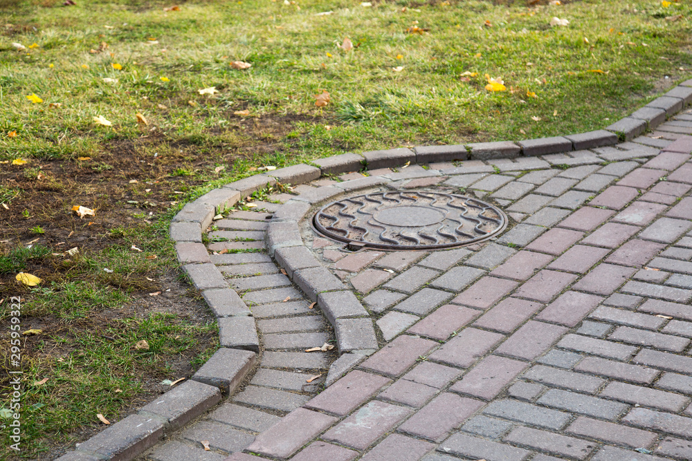 The sidewalk is curved from paving stones of rectangular shape with a ...