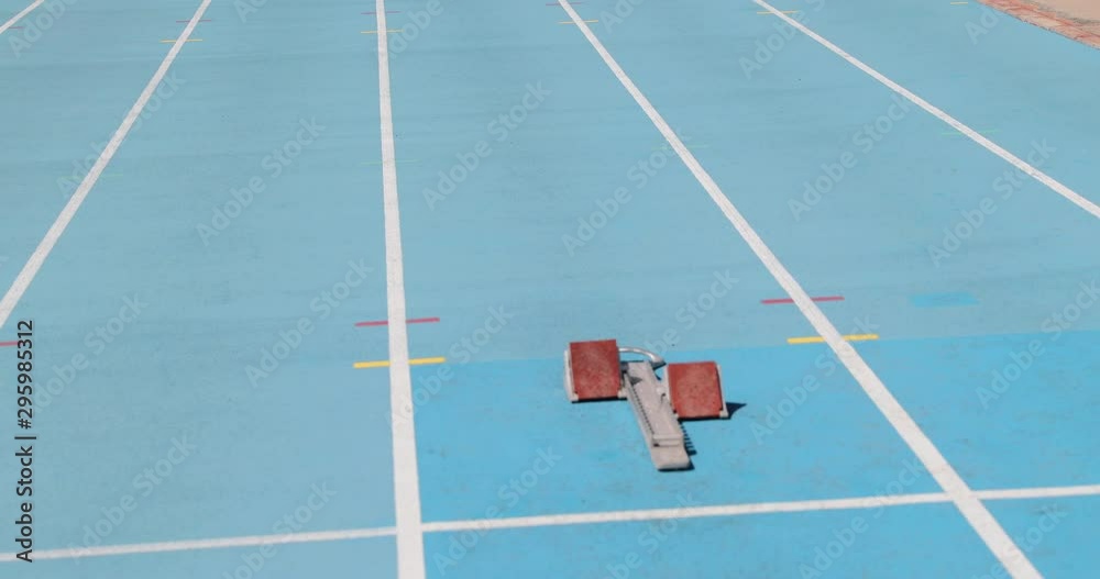 Sprinter runner athlete running in starting blocks training sprinting ...