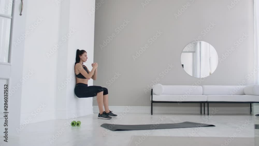 A woman in a static position carries out a grueling exercise leaning ...