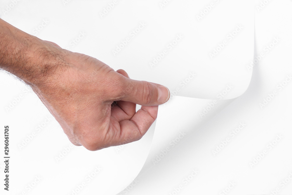man's hand pull up a bottom corner of a white paper sheet to uncover a ...