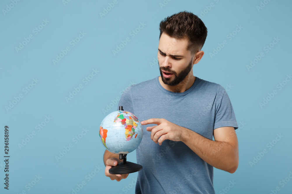 Young preoccupied man in casual clothes posing isolated on blue wall ...