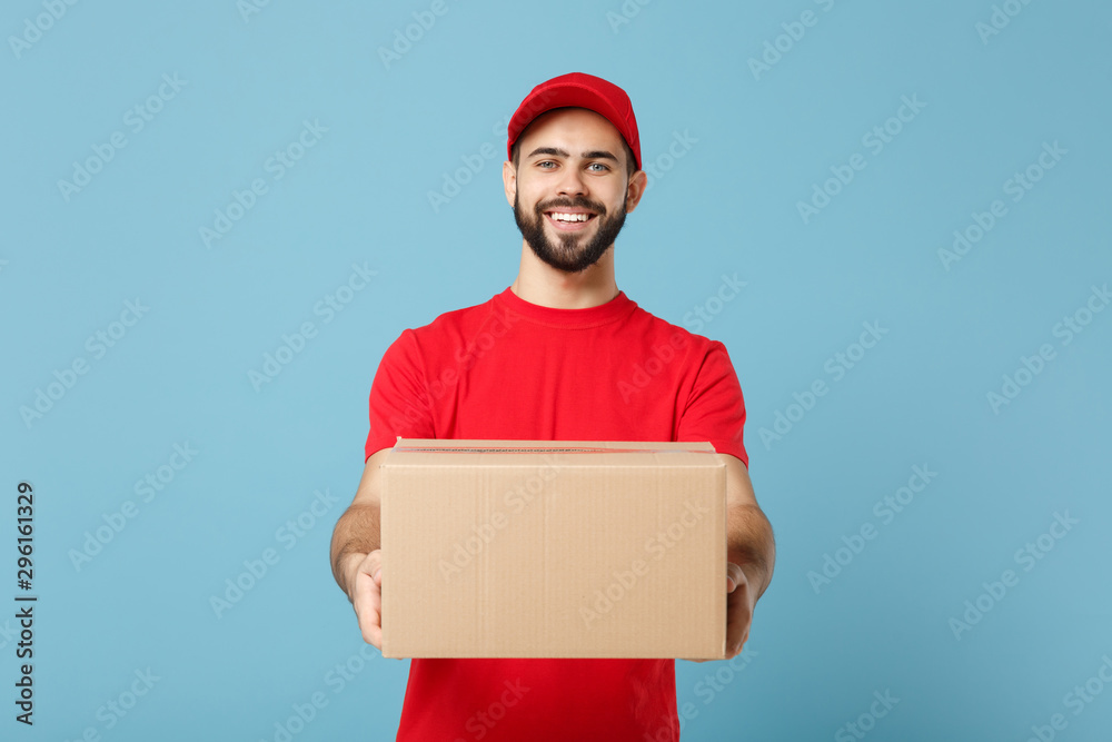 Delivery man in red uniform isolated on blue background, studio ...