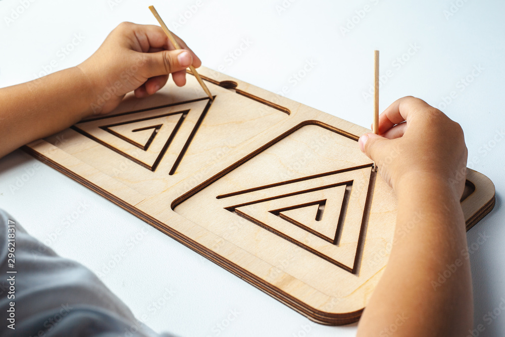 Montesori wooden game for the development of children. Child draws on a ...