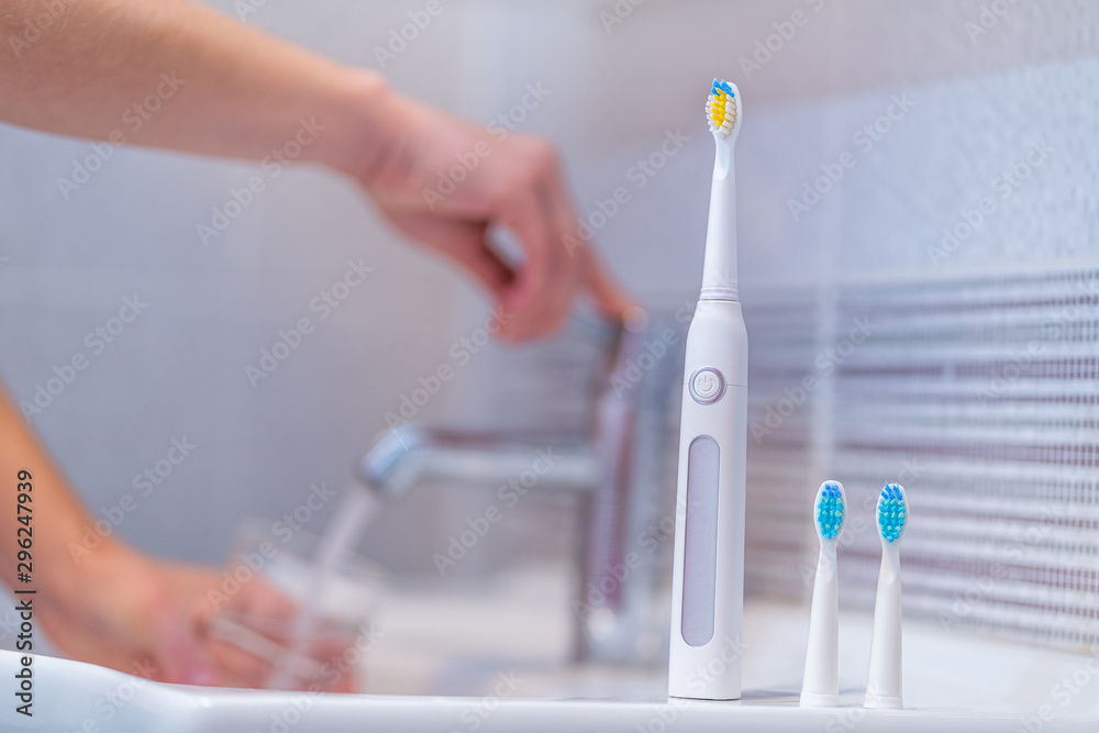 Ultrasonic electric toothbrush with interchangeable nozzles in bathroom ...