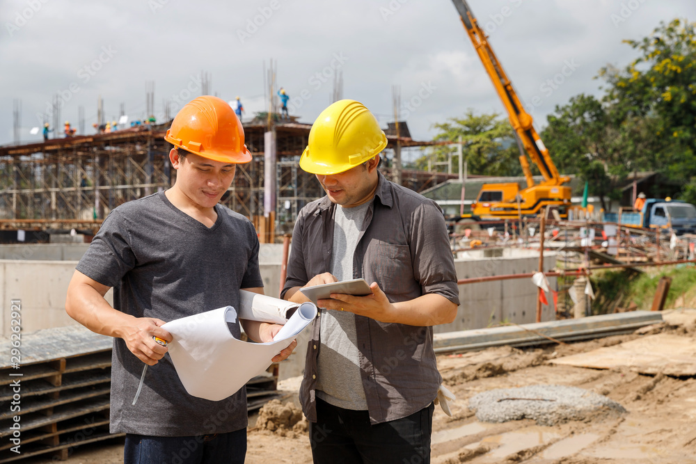 Team of construction workers discussing project details with blueprint ...