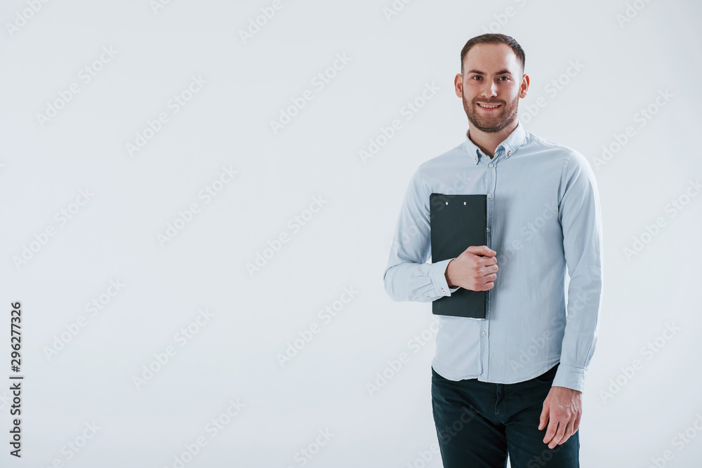 Black notepad in hands. Man in official clothes stands against white ...