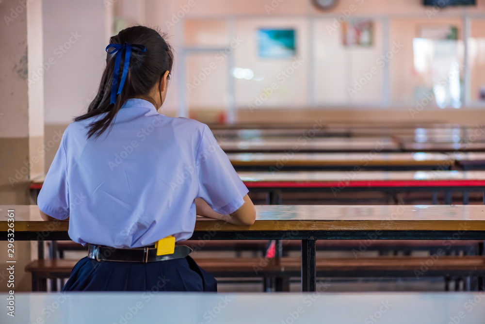 Thai female high school student is sitting alone in the school ...