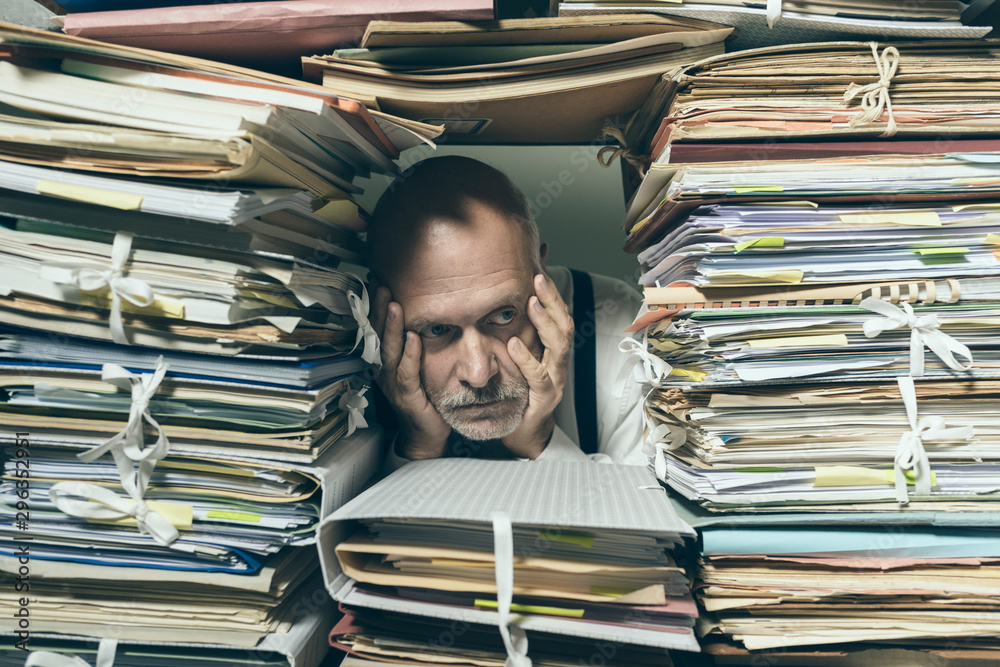 Depressed businessman overwhelmed with paperwork Stock Photo | Adobe Stock