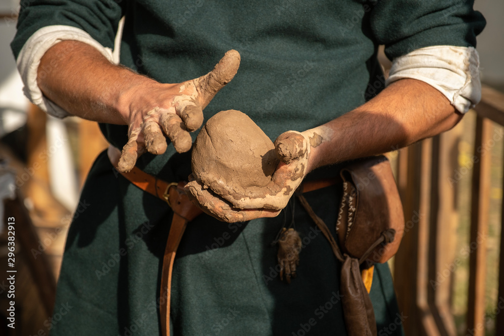 Reconstruction of an ancient craft. An artisan wrinkles clay to create ...