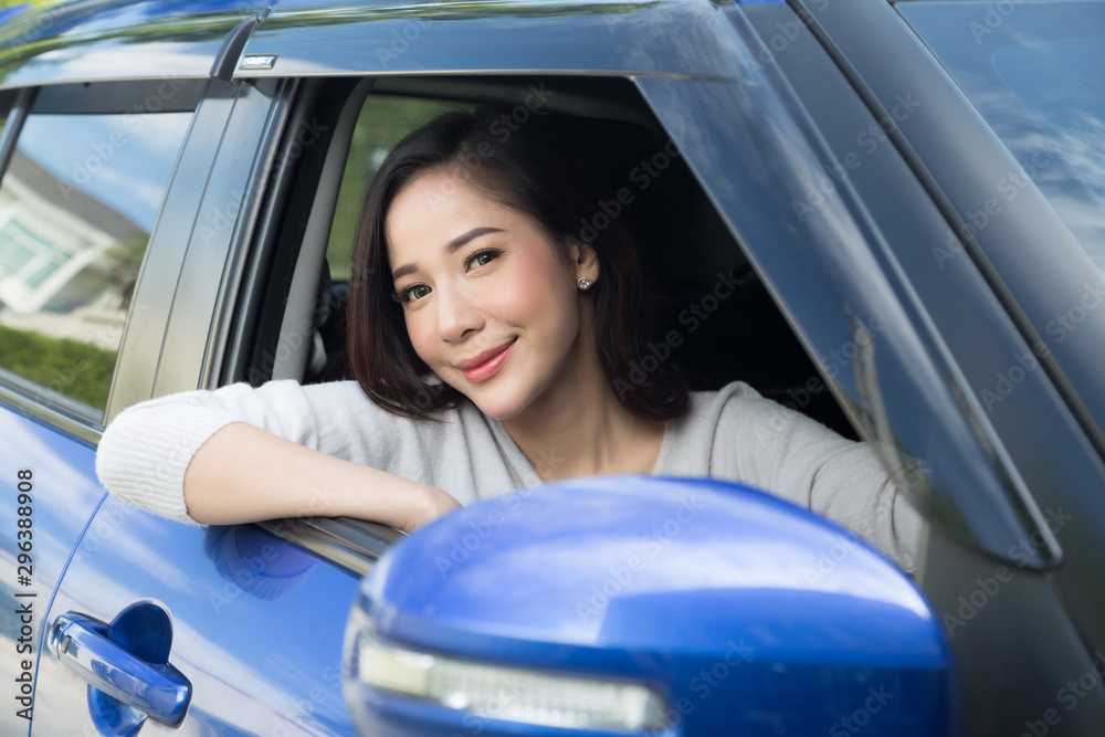 Portrait of Asian woman driving a car in a happy positive expression ...