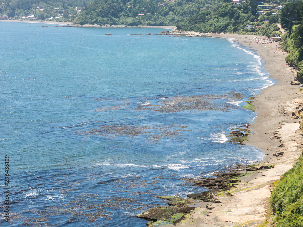 Beach lovers facing the Pacific Ocean from the fort of Niebla village ...