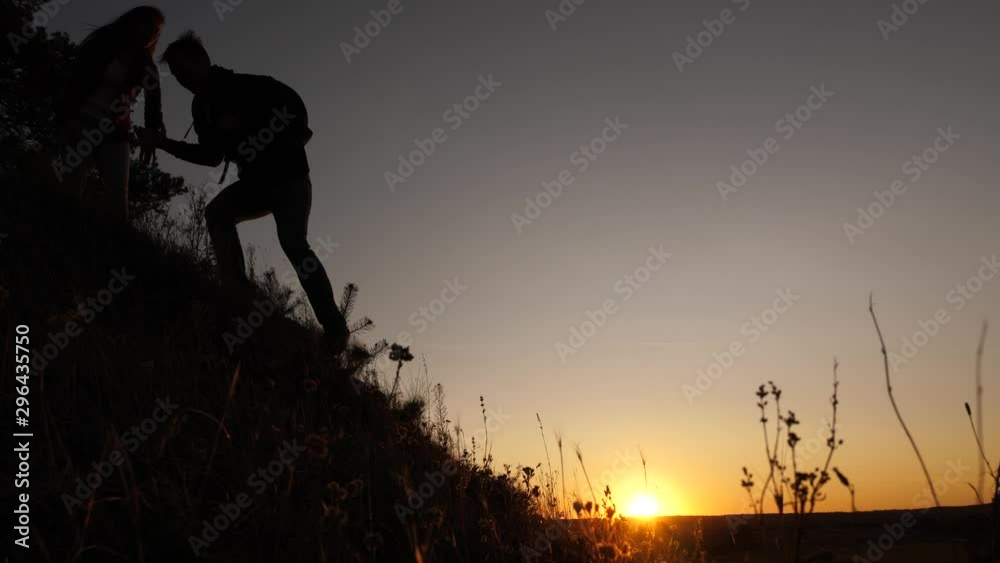 tourists go down from the goy in the sunset, holding hands. male ...