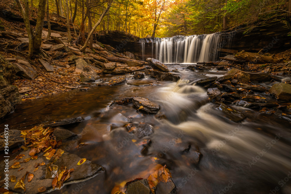 Autumn waterfall scenery with fallen leaves and beautiful fall colors ...