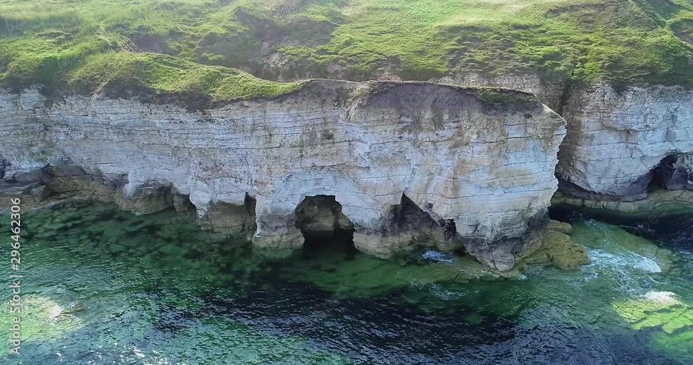 Beautiful chalk coastal cliffs at low tide, with visible cracks showing ...