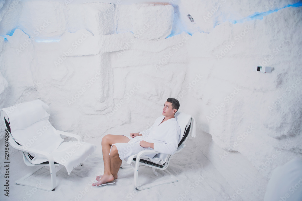 A young man is resting in the salt room, Spa treatments for men with ...