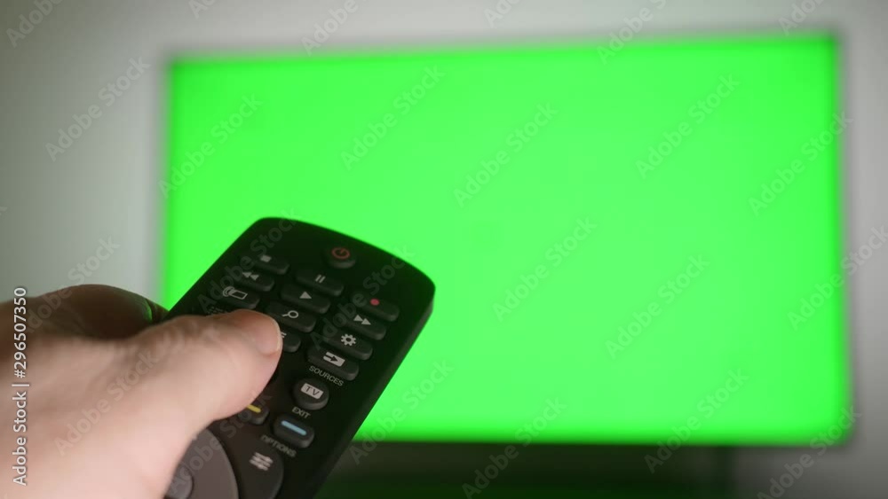 Male hand operating a remote control for a smart TV. Locked shot with ...