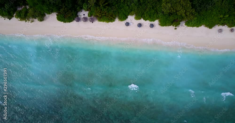 Sideways panning view from above of a tropical beach shoreline with ...