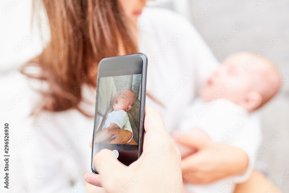 Photo of baby and mother with the smartphone Stock Photo | Adobe Stock