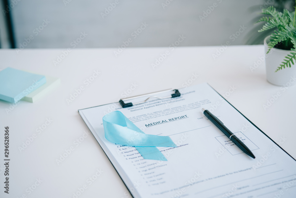 blue awareness ribbon, medical report, pen and sticky notes on white ...