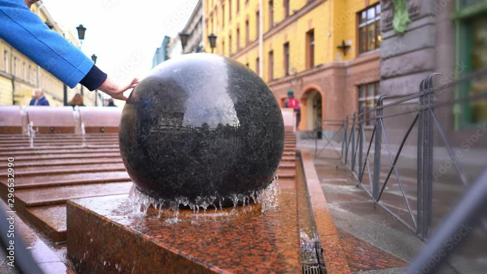 a round large marble ball in water spins, a landmark is a statue of a ...