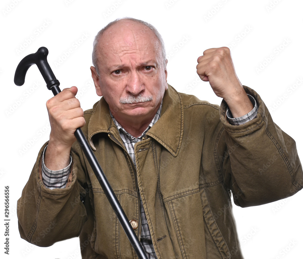 Old angry man threatening with a cane in studio Stock Photo | Adobe Stock