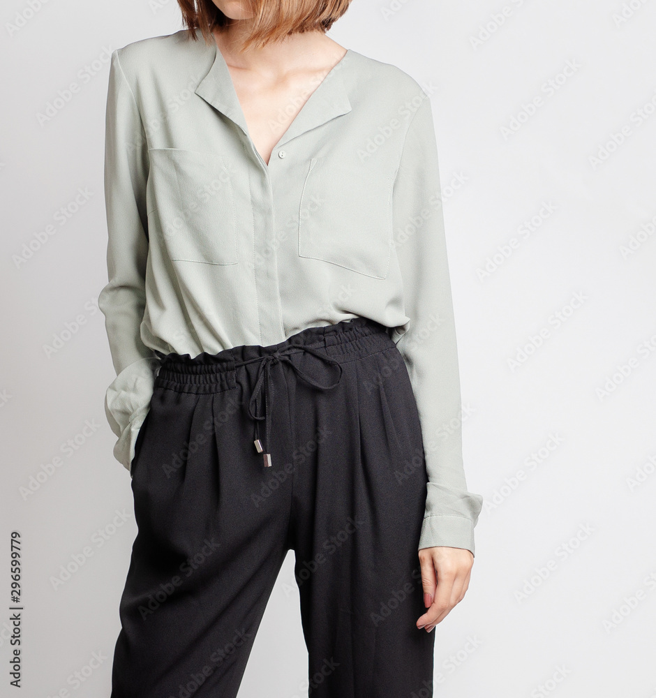 Young woman wearing simple stylish outfit with a neutral shirt and ...