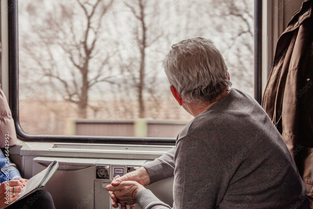 man looking out the windowAn old man looks out the window of a train ...