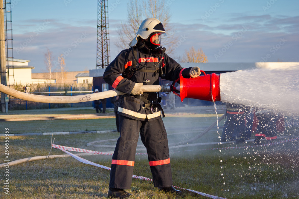 Fireman with fire extinguishing foam spraying hose Stock Photo | Adobe ...
