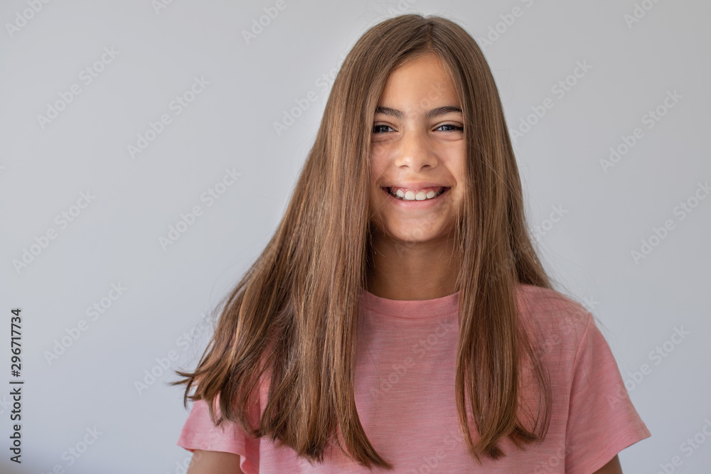 Portrait of a 9 years old girl with long hair. She is looking at camera ...