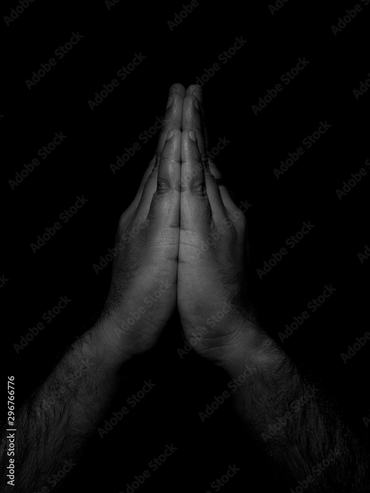 Low key black and white photo of a man with hands placed together ...