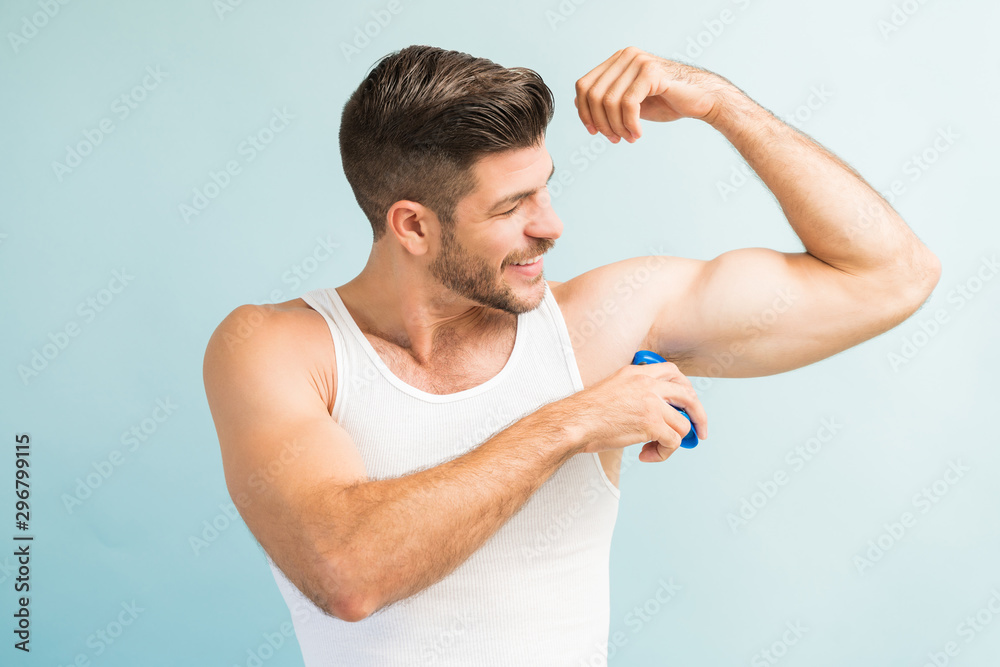 Attractive Hispanic Man Adding Fragrance To Muscular Body Stock Photo ...
