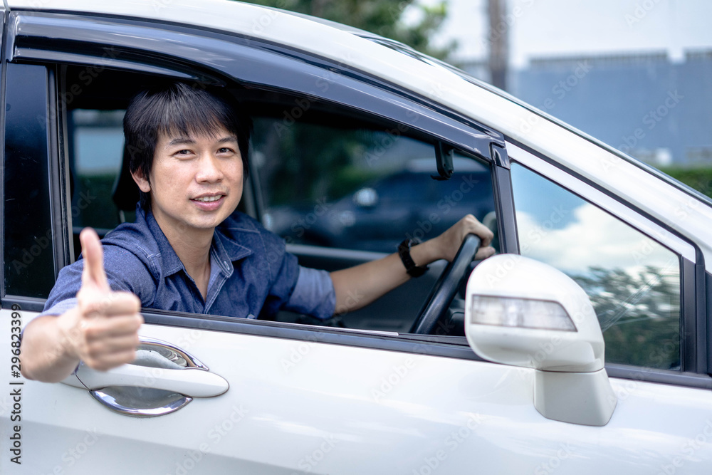 Smiling asian man sitting in his van with thumbs up. Stock Photo ...