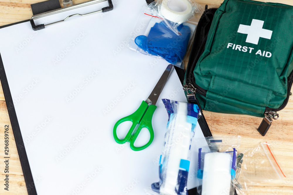 Green first aid kit on a table with a clipboard Stock Photo | Adobe Stock