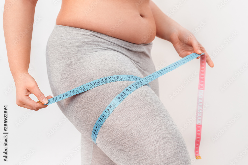 Body Care. Chubby girl with bare belly standing isolated on white with ...