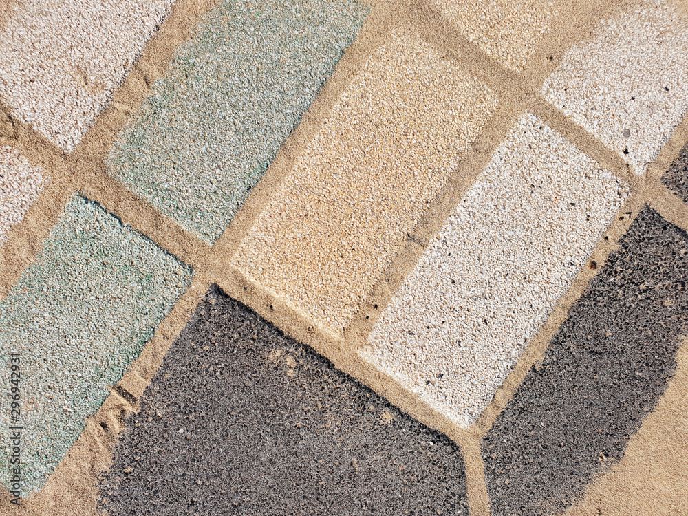 Multi-colored rectangular paving slabs covered with sea sand ...