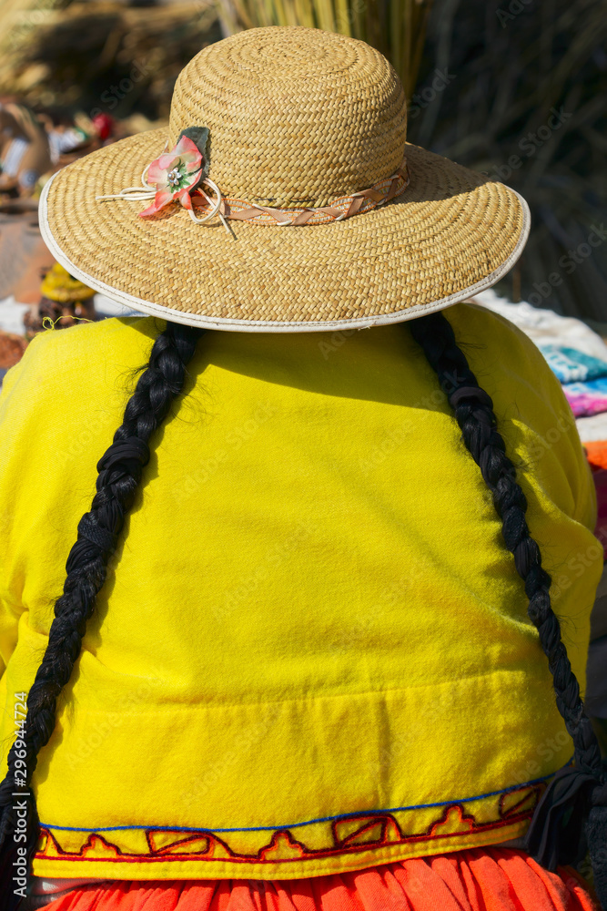 Peruvian women with braided hair and wearing traditional hat in uros ...
