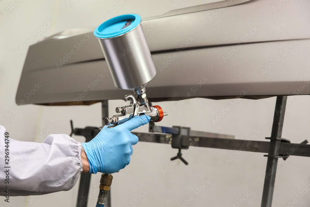 car painter's hand is painting a car detail with spray gun. painting a ...