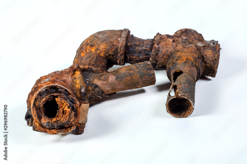 Fragments of old cast-iron water pipes on white background. After many ...
