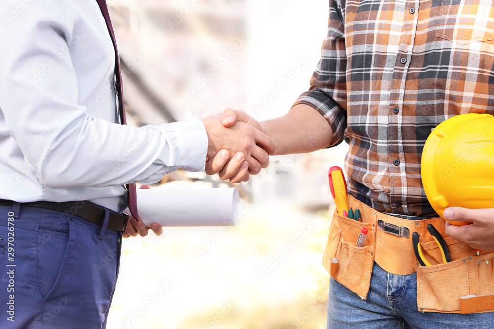 Male architect and builder shaking hands outdoors Stock Photo | Adobe Stock