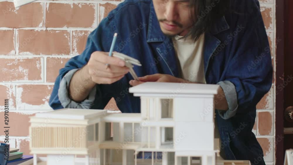 Smart asian male Architect working with his architectural model ...